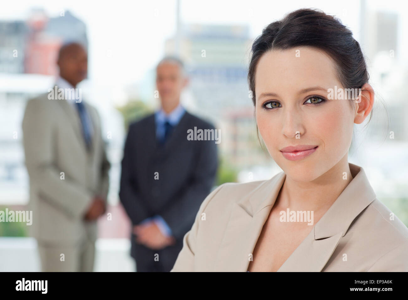 Young secretary standing in front of two executives in a relaxed way ...