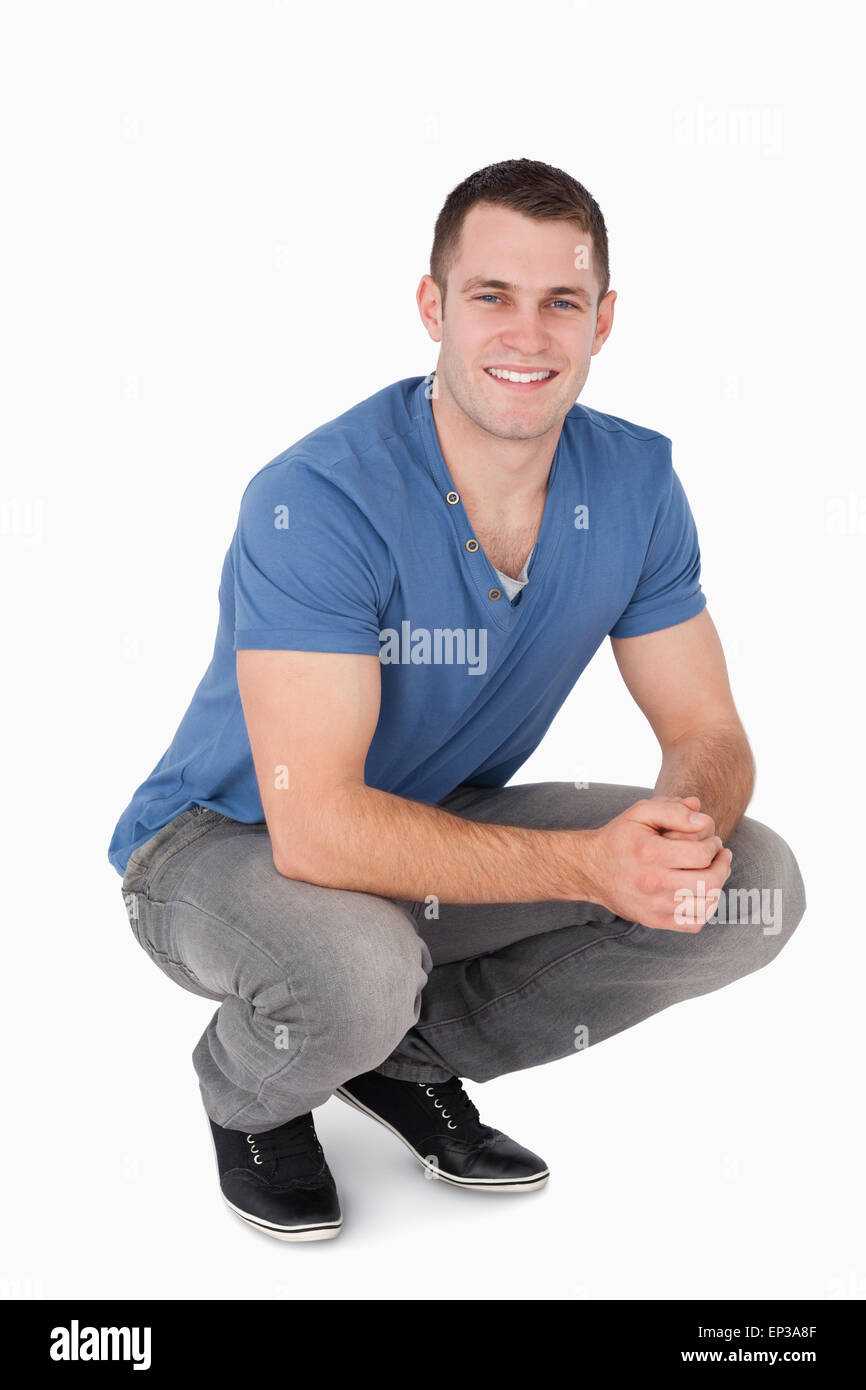 Portrait of a man squatting Stock Photo - Alamy