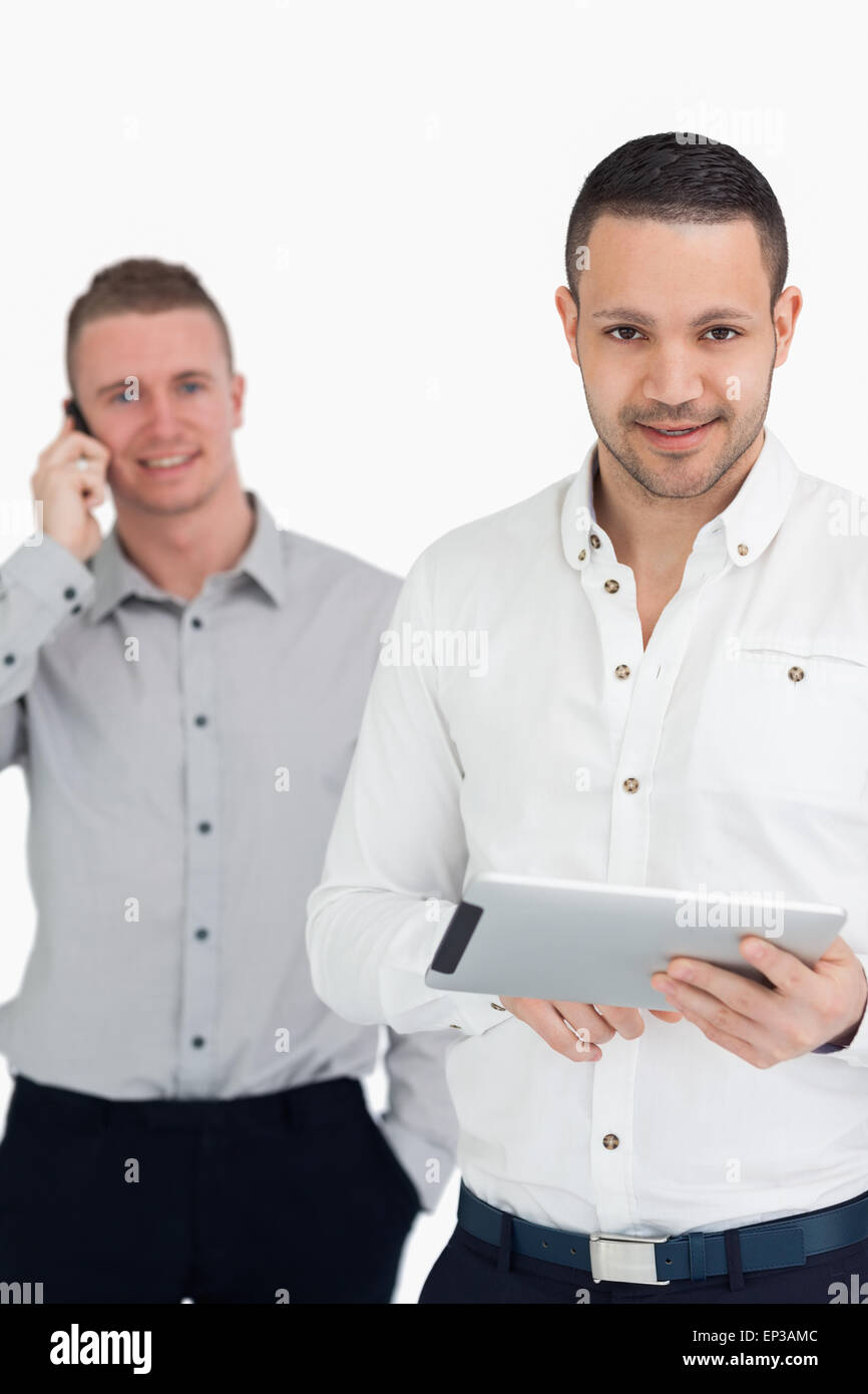 Two smiling men using phone and tablet computer Stock Photo - Alamy