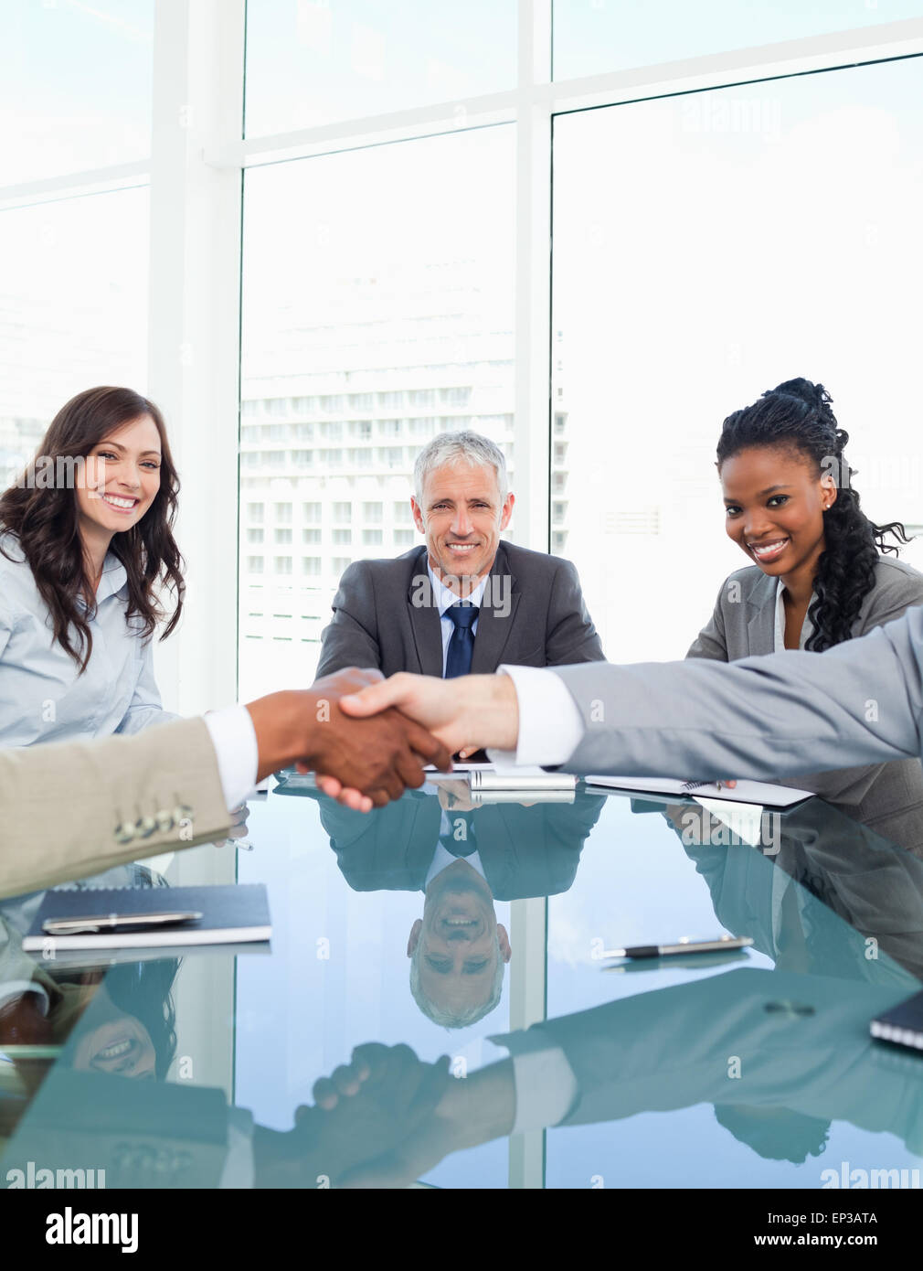 Businesswomen smiling during a meeting while looking at colleagues ...