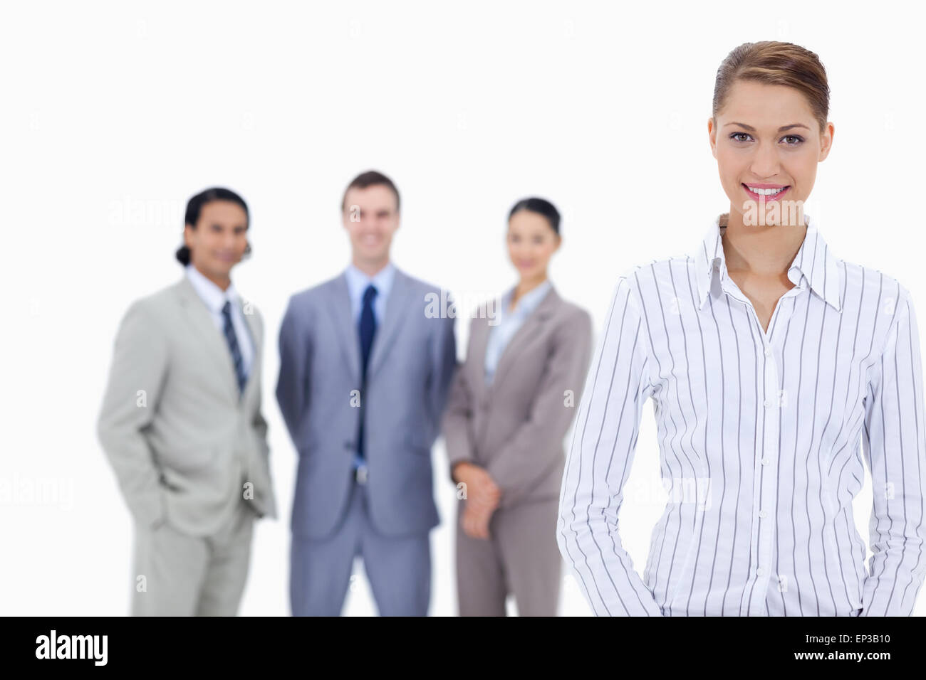 Secretary smiling with business people in background Stock Photo - Alamy