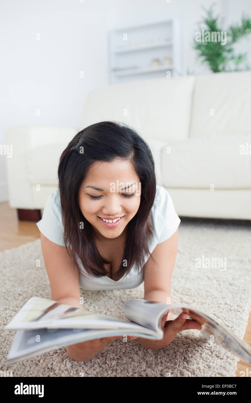 Woman reading a magazine as she lays on the floor Stock Photo - Alamy