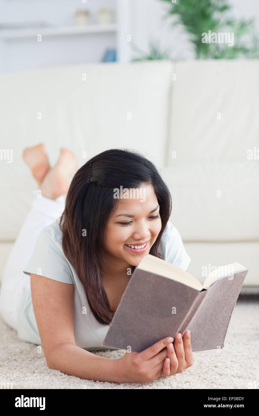 Woman lays on the floor as she reads a book Stock Photo - Alamy