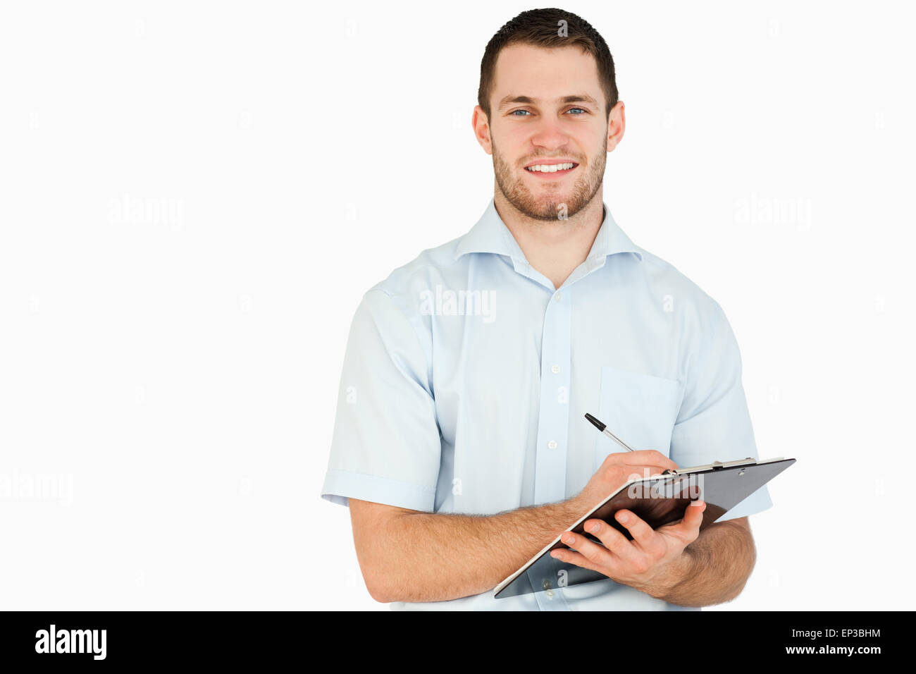 Smiling young post employee taking notes on clipboard Stock Photo - Alamy