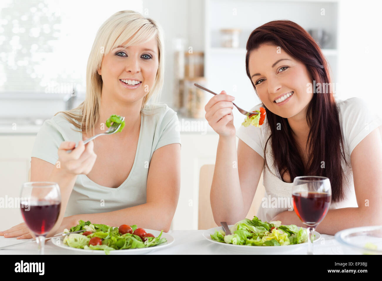 Cheerful young Women eating salad Stock Photo - Alamy