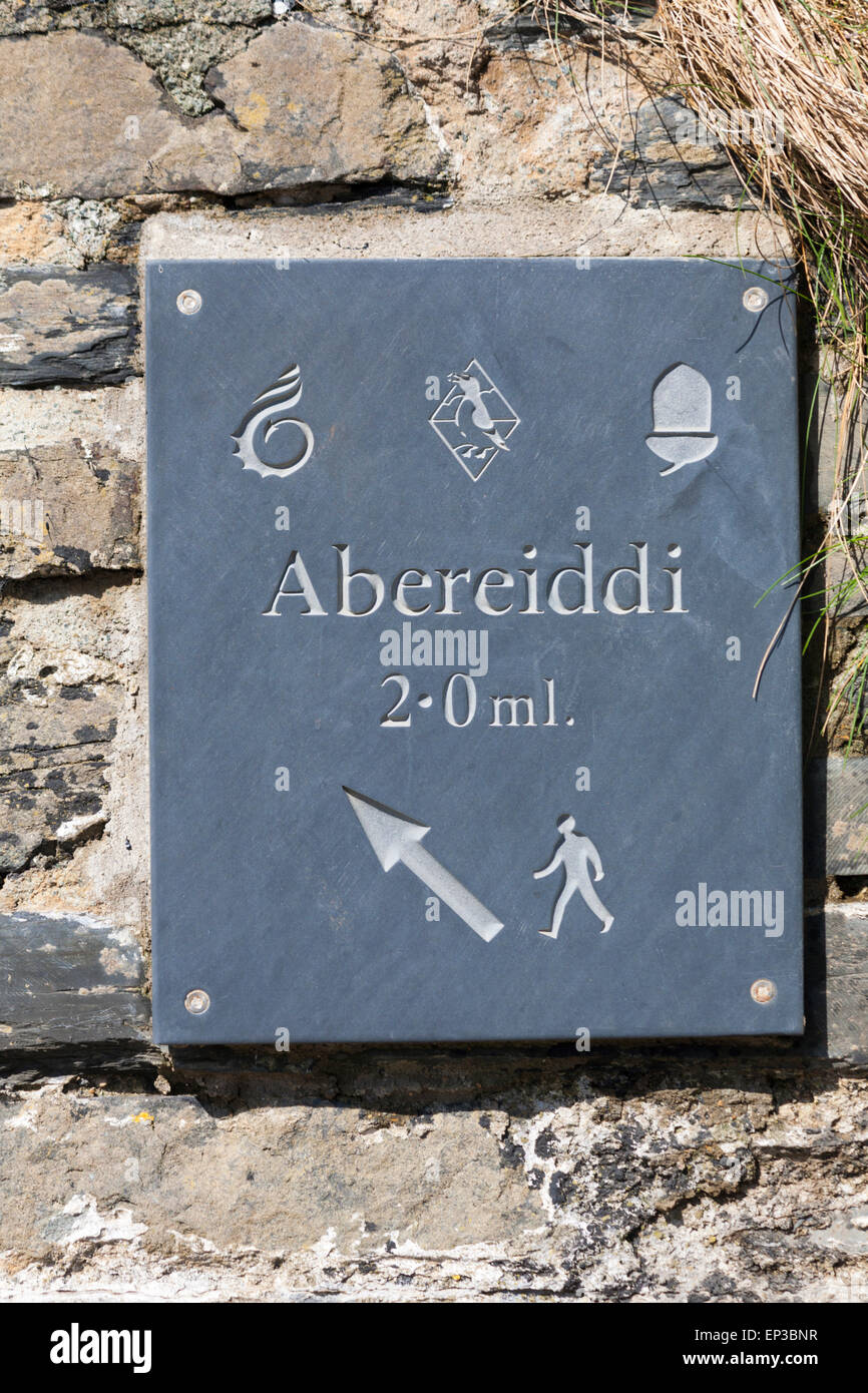Sign on stone wall at Porthgain showing distance and direction to ...
