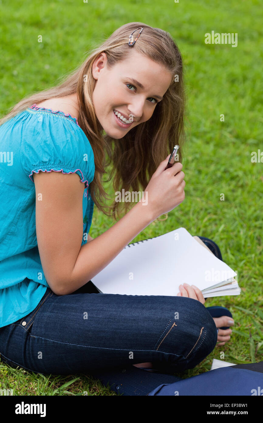 Young smiling student holding her pen while looking at the camera Stock ...