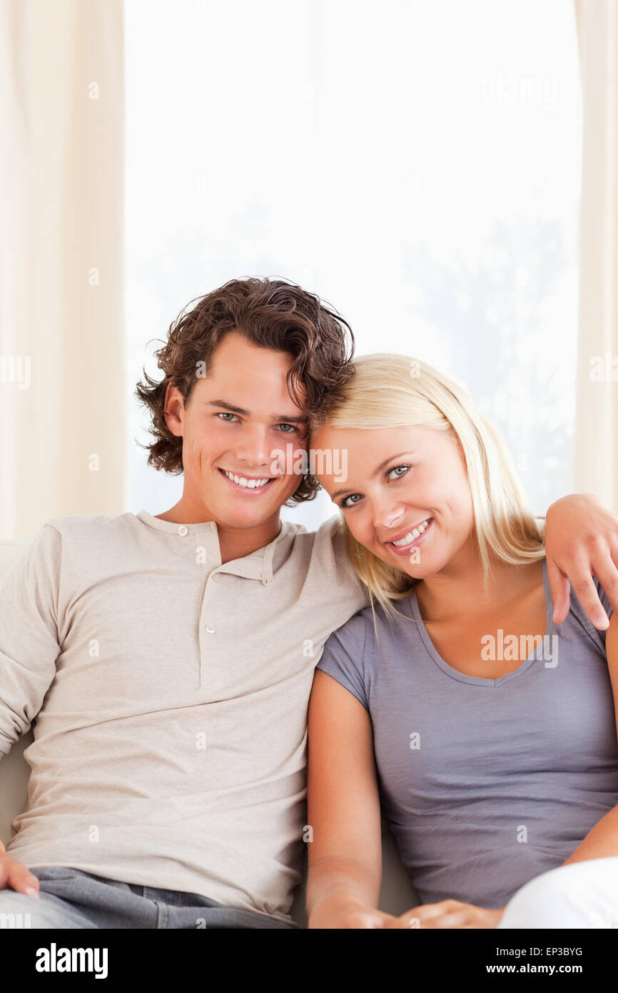 Portrait of a smiling couple sitting on a sofa Stock Photo - Alamy