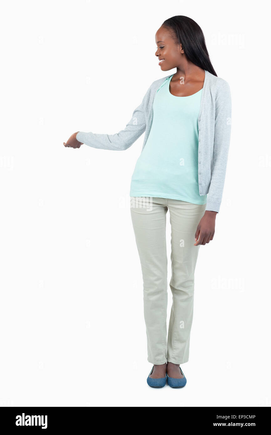 Smiling young woman pointing at something behind her Stock Photo - Alamy