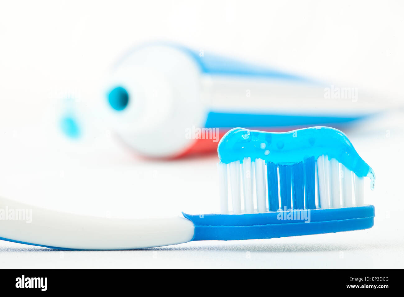 Toothbrush with blue toothpaste next to a tube of toothpaste Stock ...