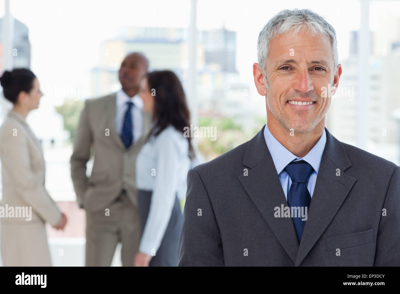 Mature smiling manager standing in front of his business team Stock ...