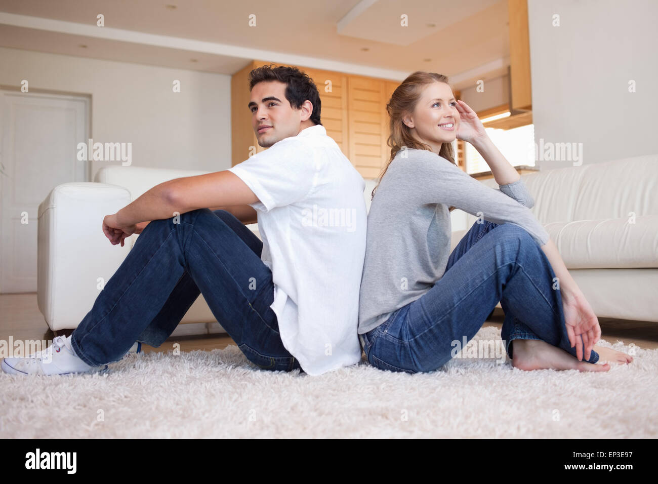 Side view of couple sitting back-to-back Stock Photo - Alamy