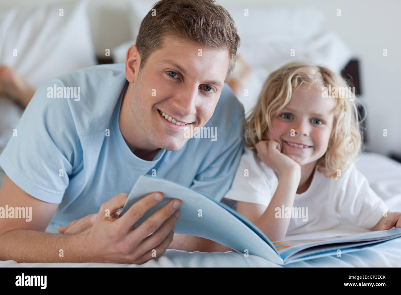 Father and son looking at magazine Stock Photo - Alamy