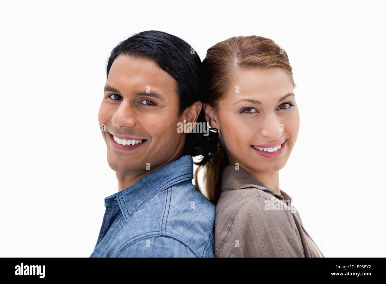Side view of smiling couple standing back to back Stock Photo - Alamy