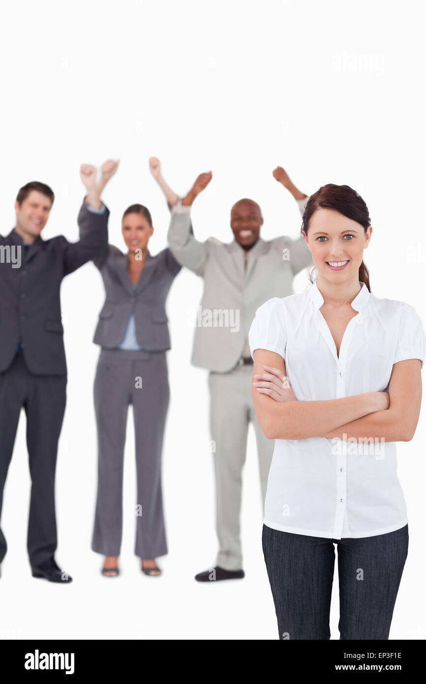 Smiling businesswoman with cheering co-workers behind her Stock Photo ...
