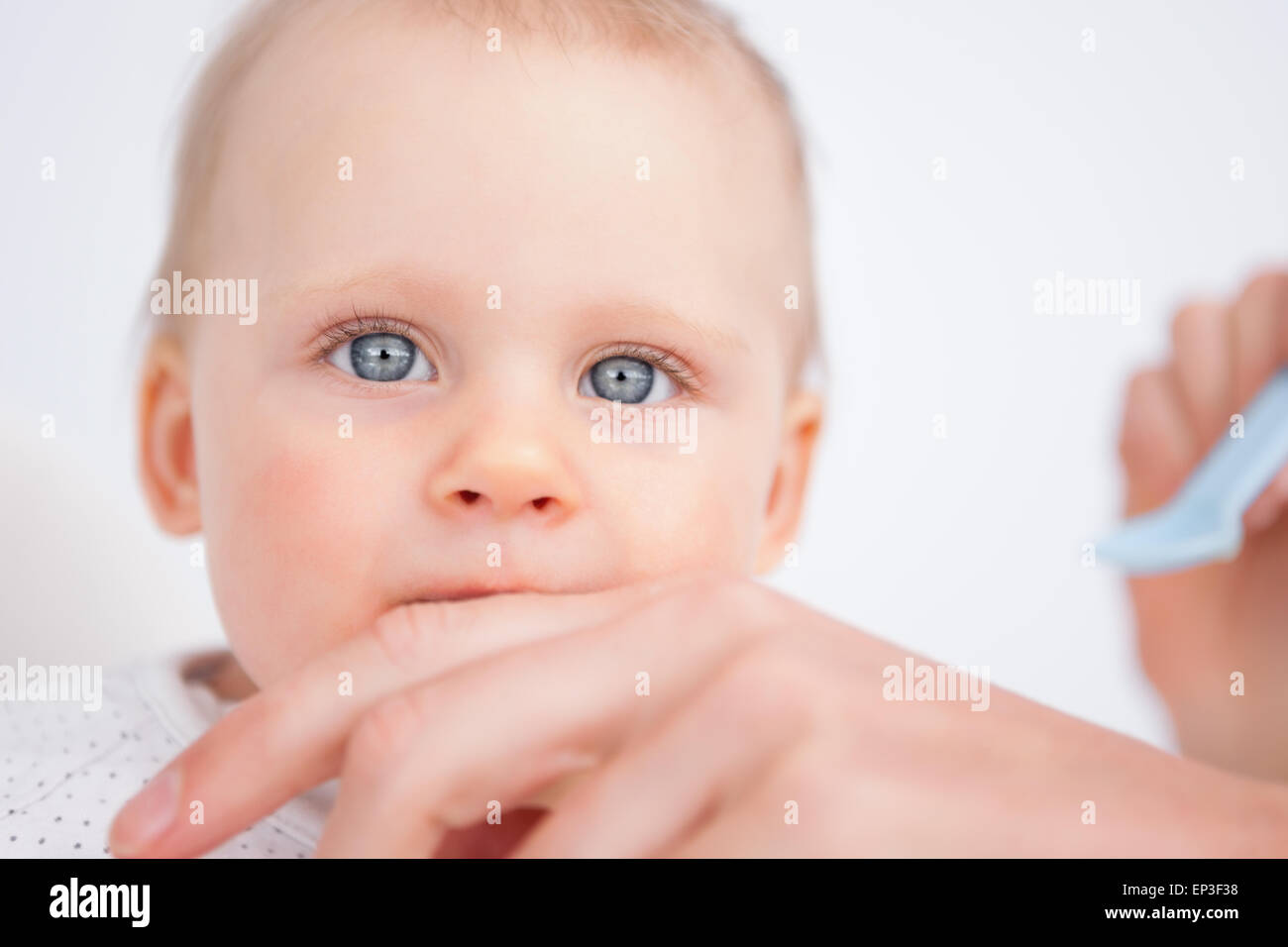 Beautiful baby biting the fingers of her mother Stock Photo - Alamy