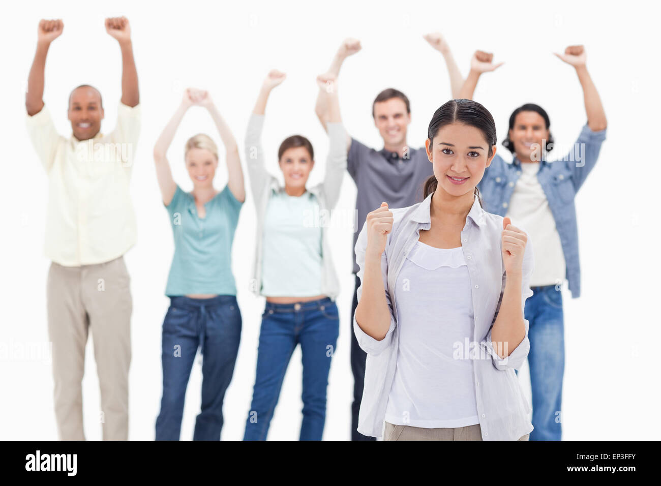 Close-up of a woman clenching her fists with people raising their arms ...