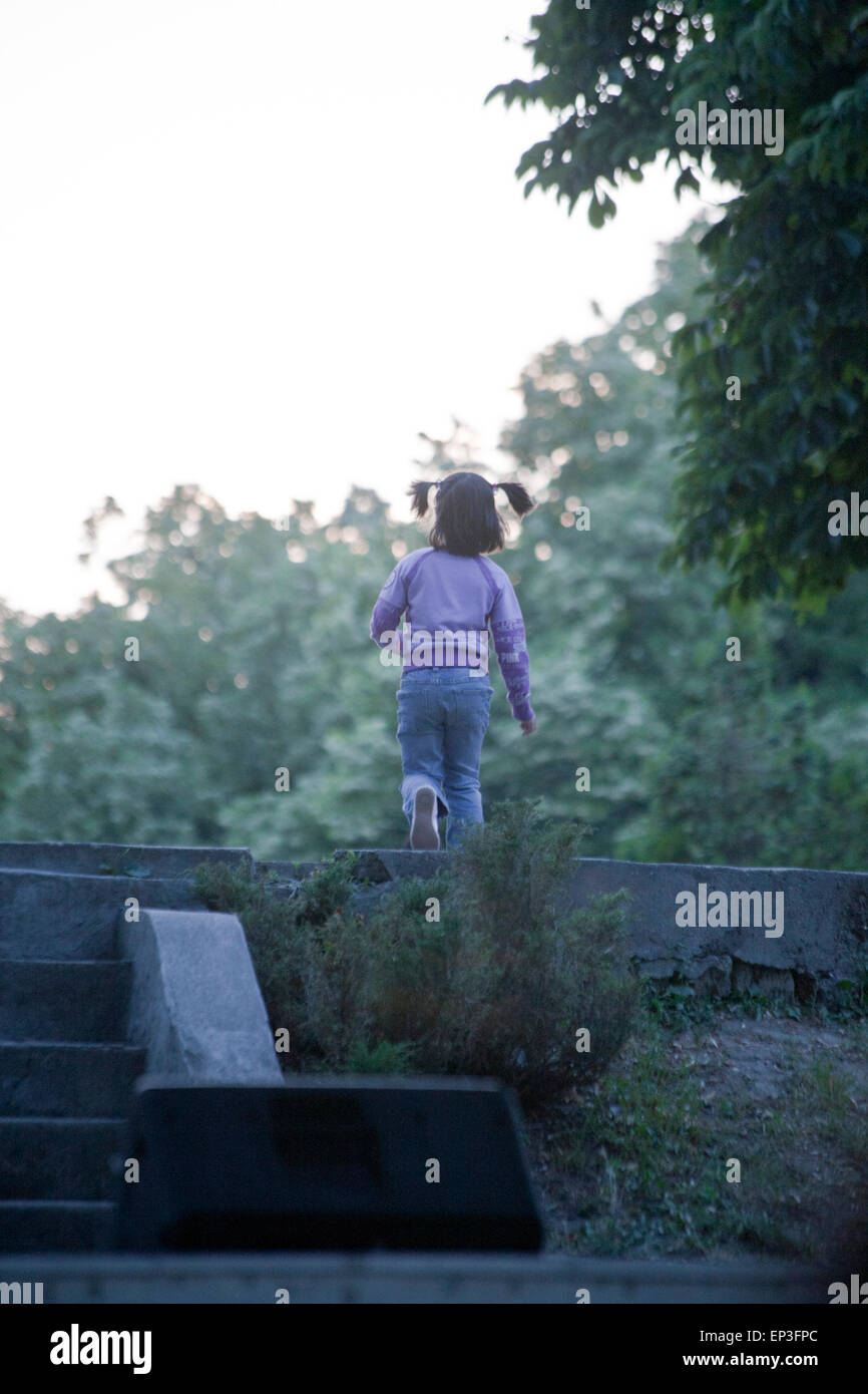 A young girl walking away Stock Photo - Alamy