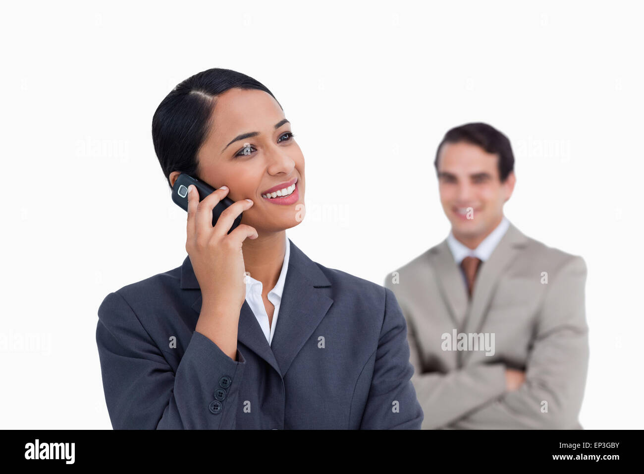 Smiling saleswoman on her mobile phone and co-worker behind her Stock ...