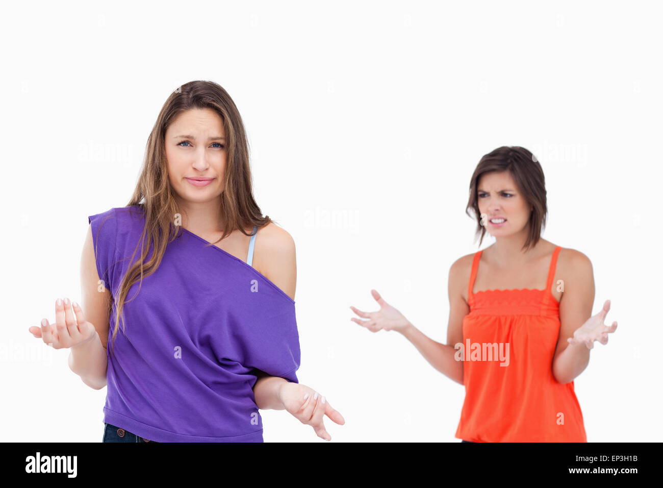 Teenage girl wondering why her friend is angry at her Stock Photo - Alamy