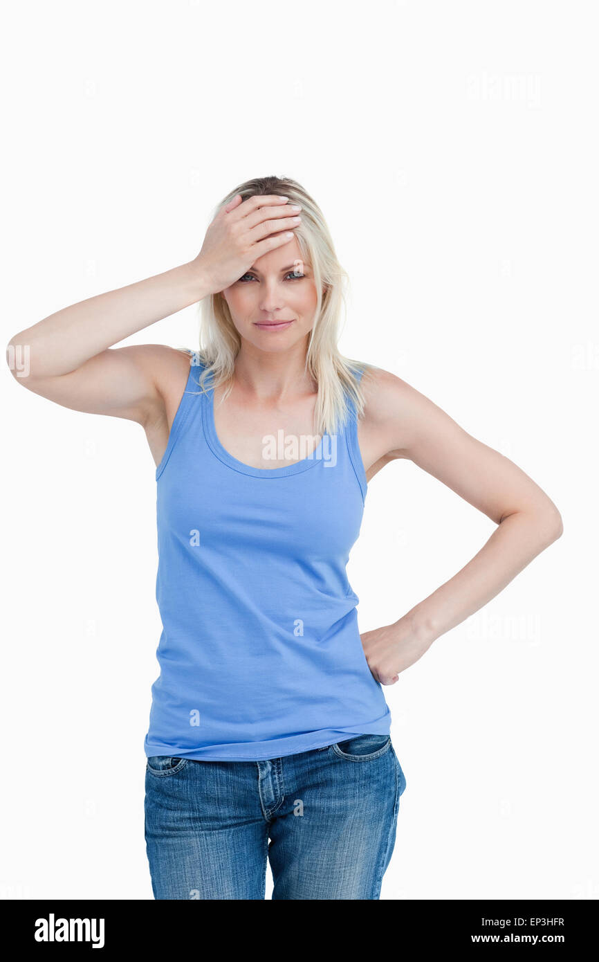 Blonde woman placing her hand on her forehead Stock Photo - Alamy