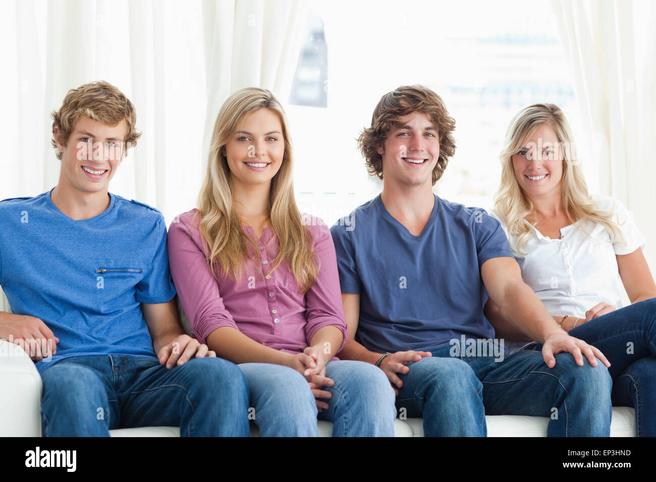 A group of people sitting together on the couch Stock Photo - Alamy