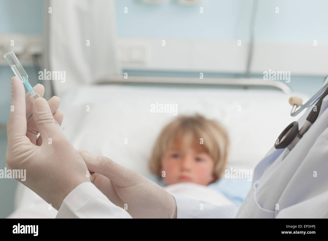 Doctor preparing a syringe in front of a child Stock Photo - Alamy