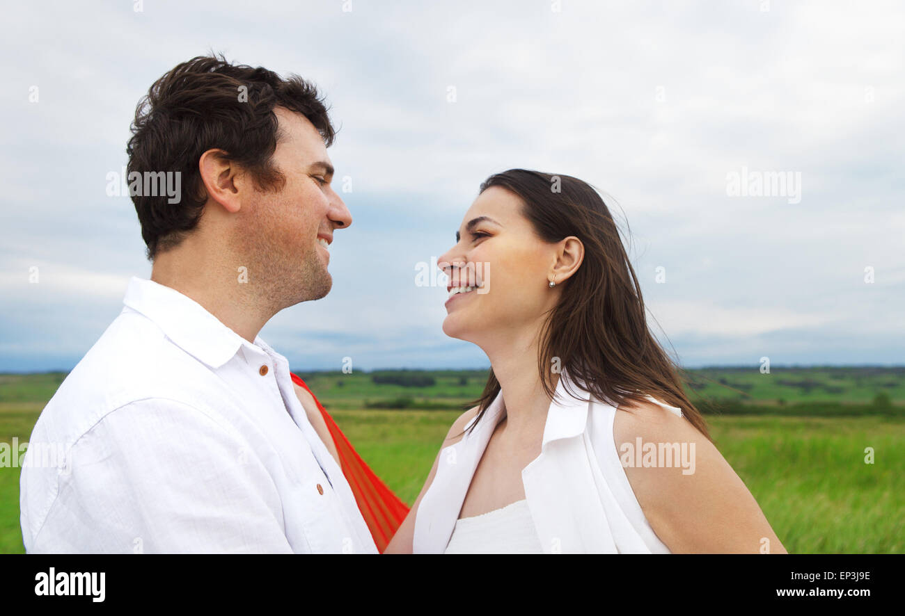 Young happy couple in love with red fabric in summer day Stock Photo ...