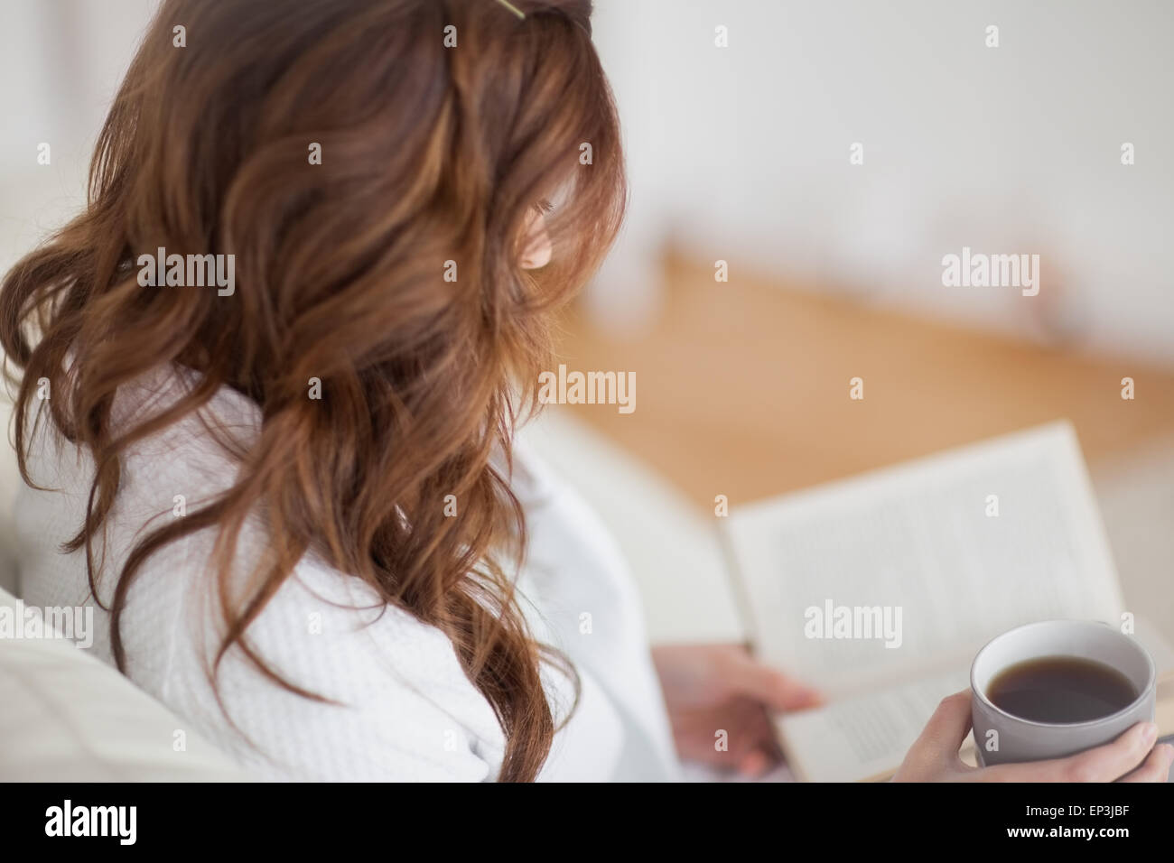 High view of a woman holding a book and a mug Stock Photo - Alamy