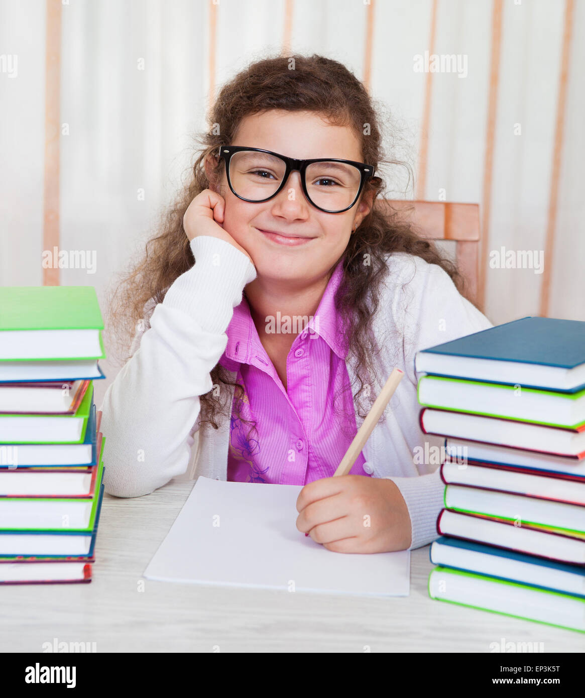 Little brunette smiling girl doing her homework Stock Photo - Alamy
