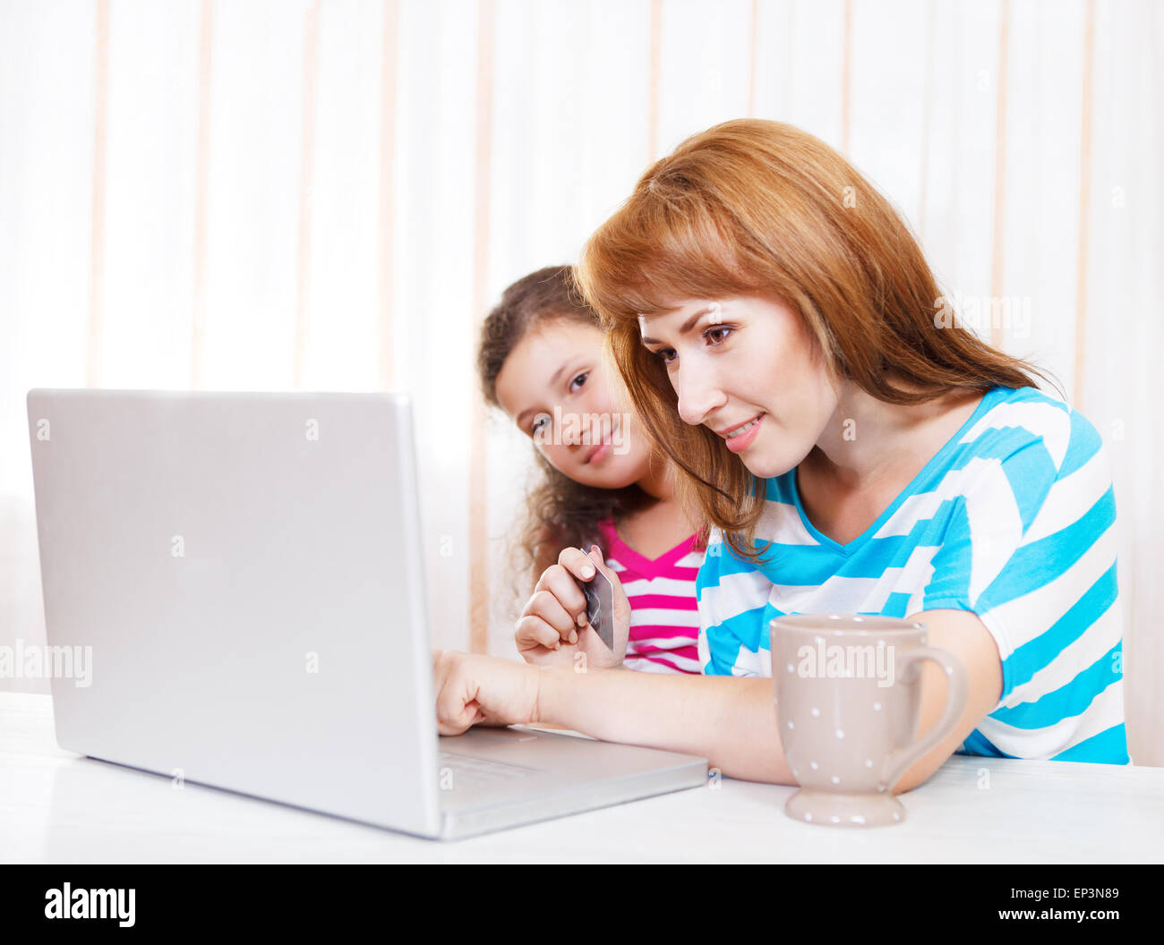 Young woman with daughter using laptop computer Stock Photo - Alamy