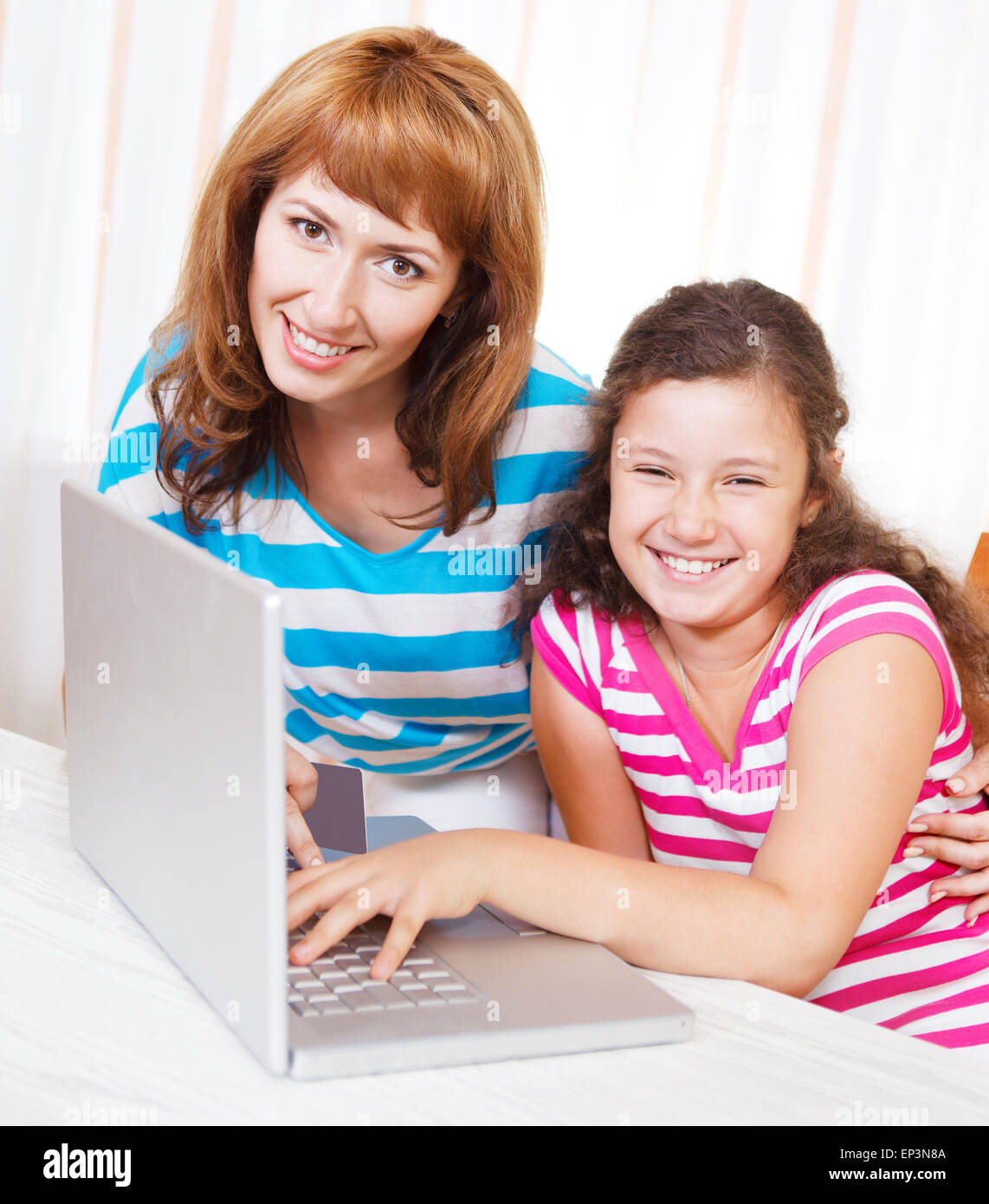 Young woman with daughter using laptop computer Stock Photo - Alamy