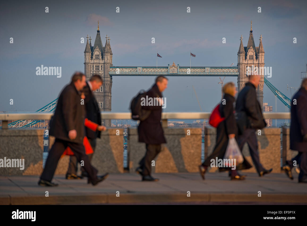 Commuters walking over London Bridge with Tower Bridge in the ...