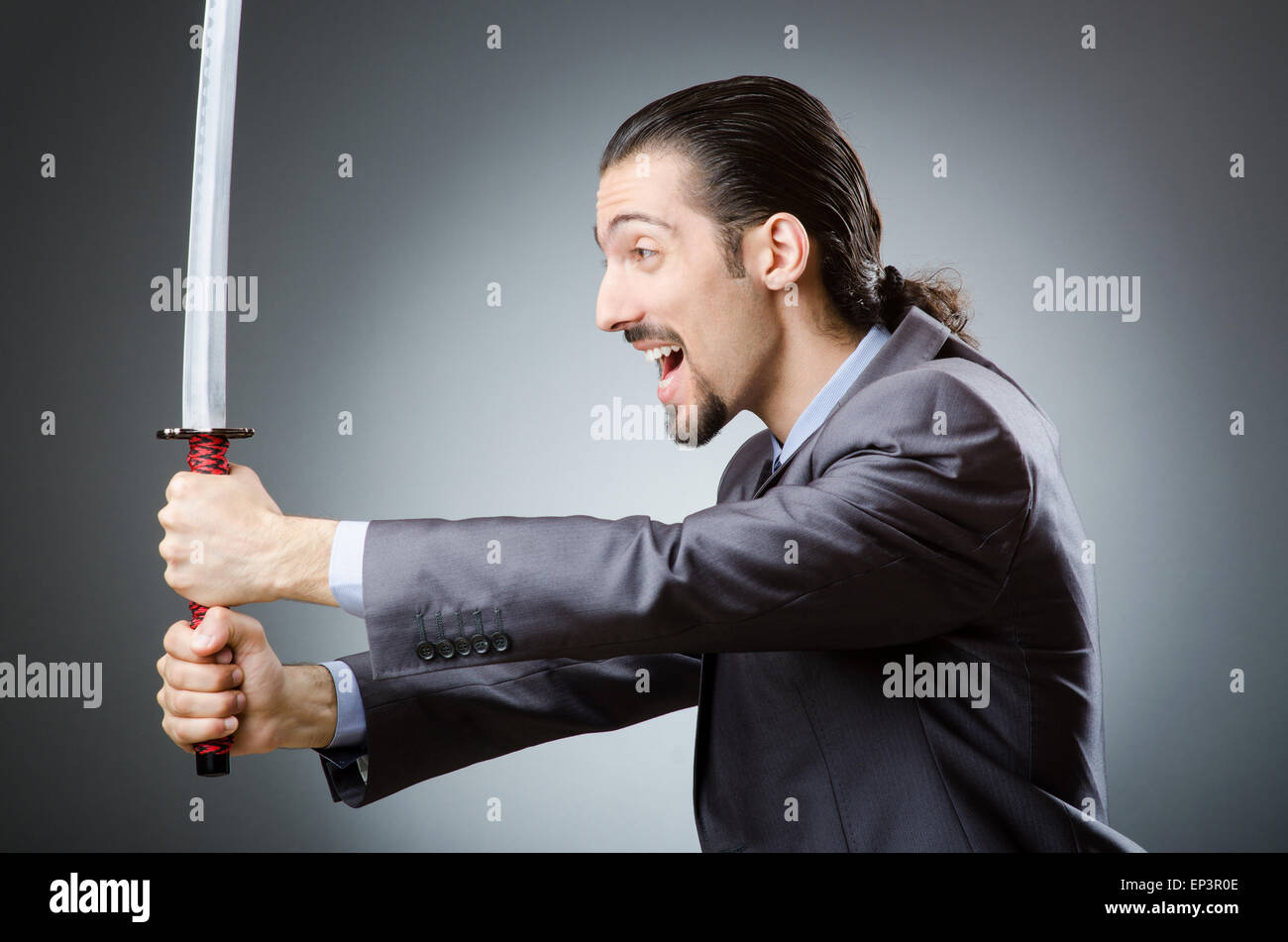 Angry businessman with sword in dark room Stock Photo - Alamy