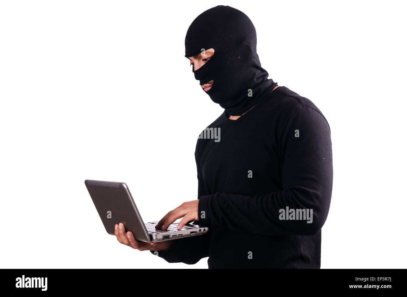 Hacker with computer wearing balaclava Stock Photo - Alamy
