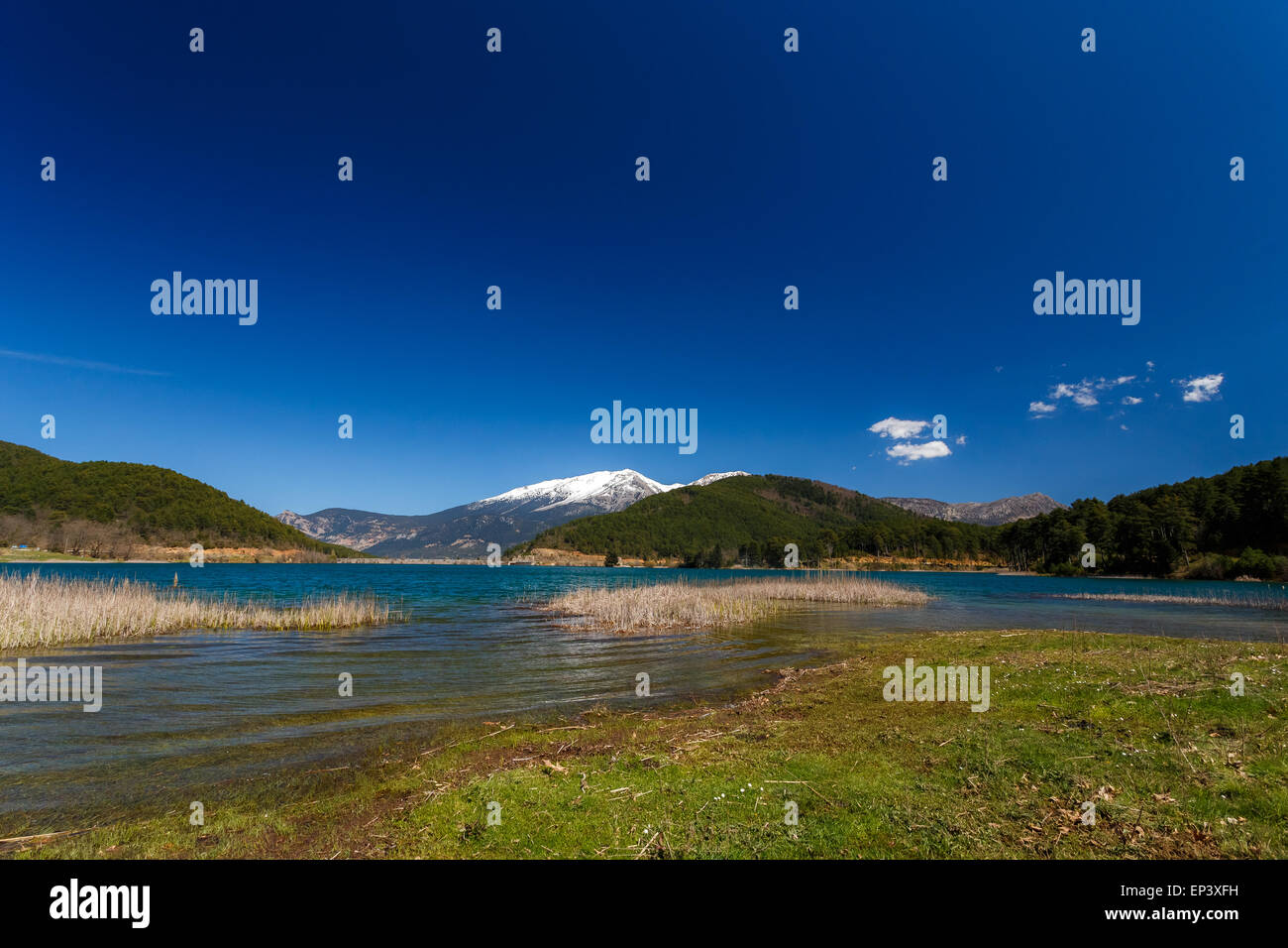 Doxa artificial Lake in Feneos area, Greece with the snowy mountains as ...
