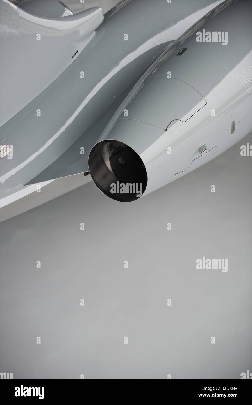 Detail of grey aircraft's engine parked in a hanger with a gray floor ...