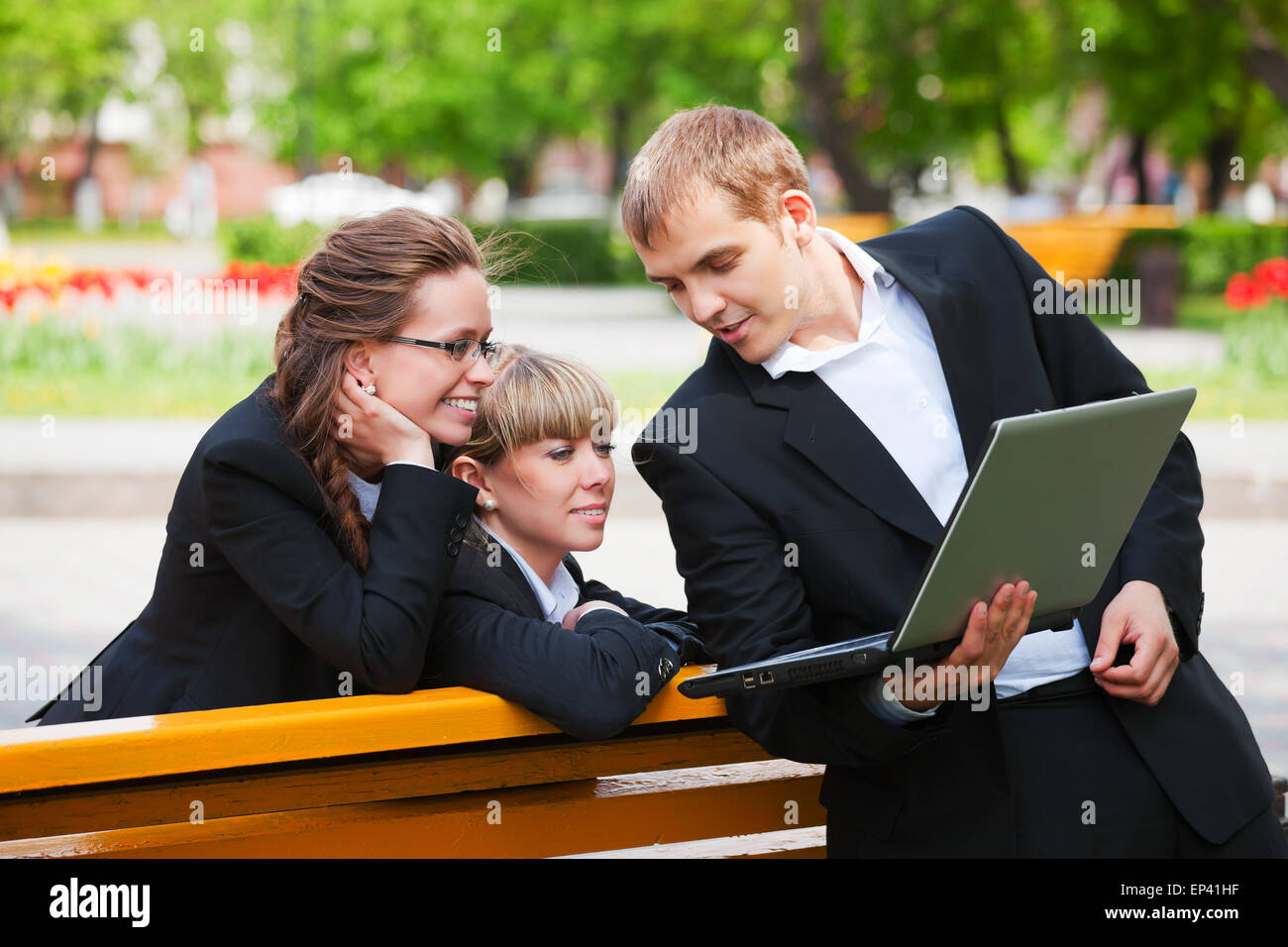 Young business people with laptop in a city park Stock Photo - Alamy