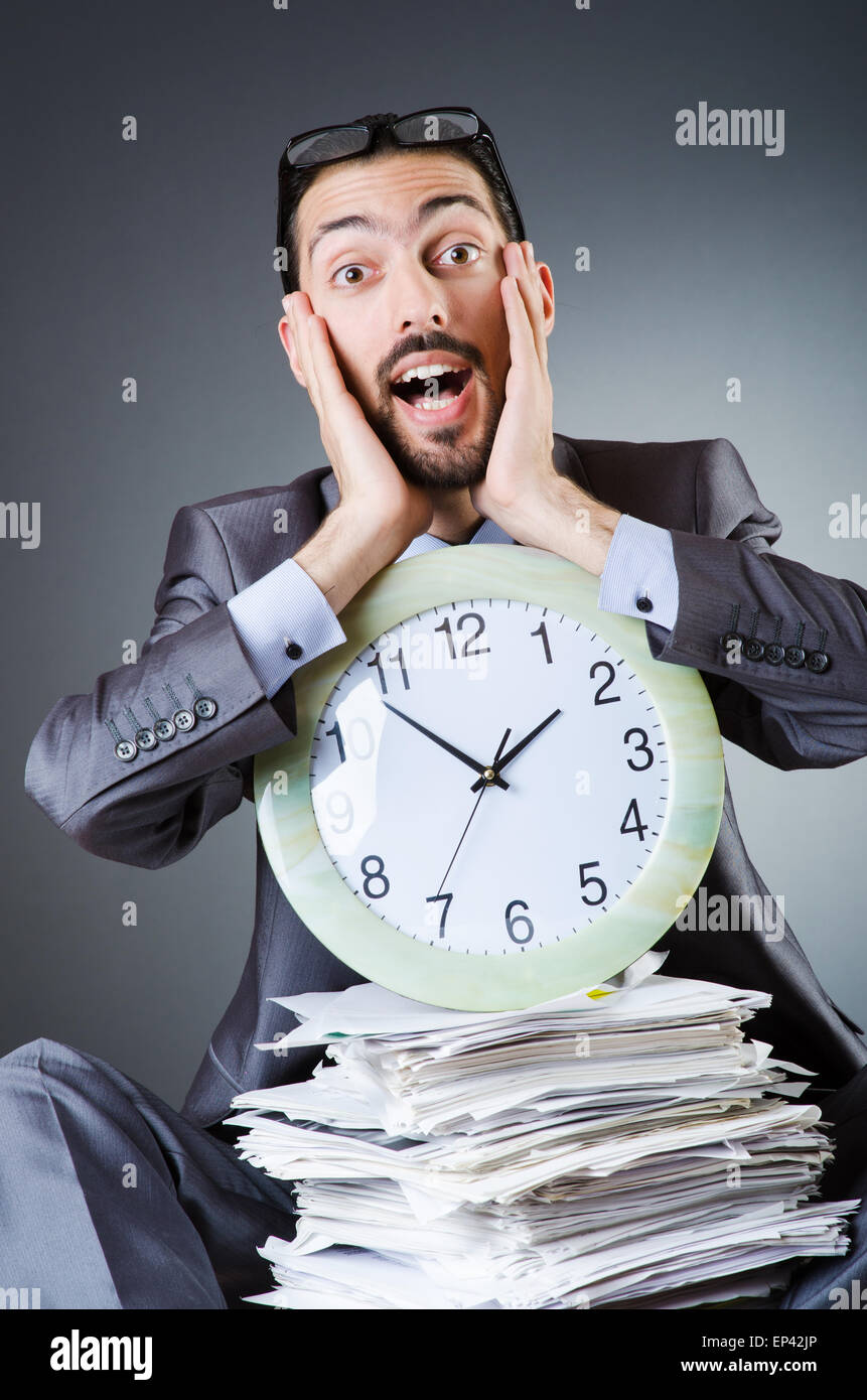 Man with clock and pile of papers Stock Photo - Alamy