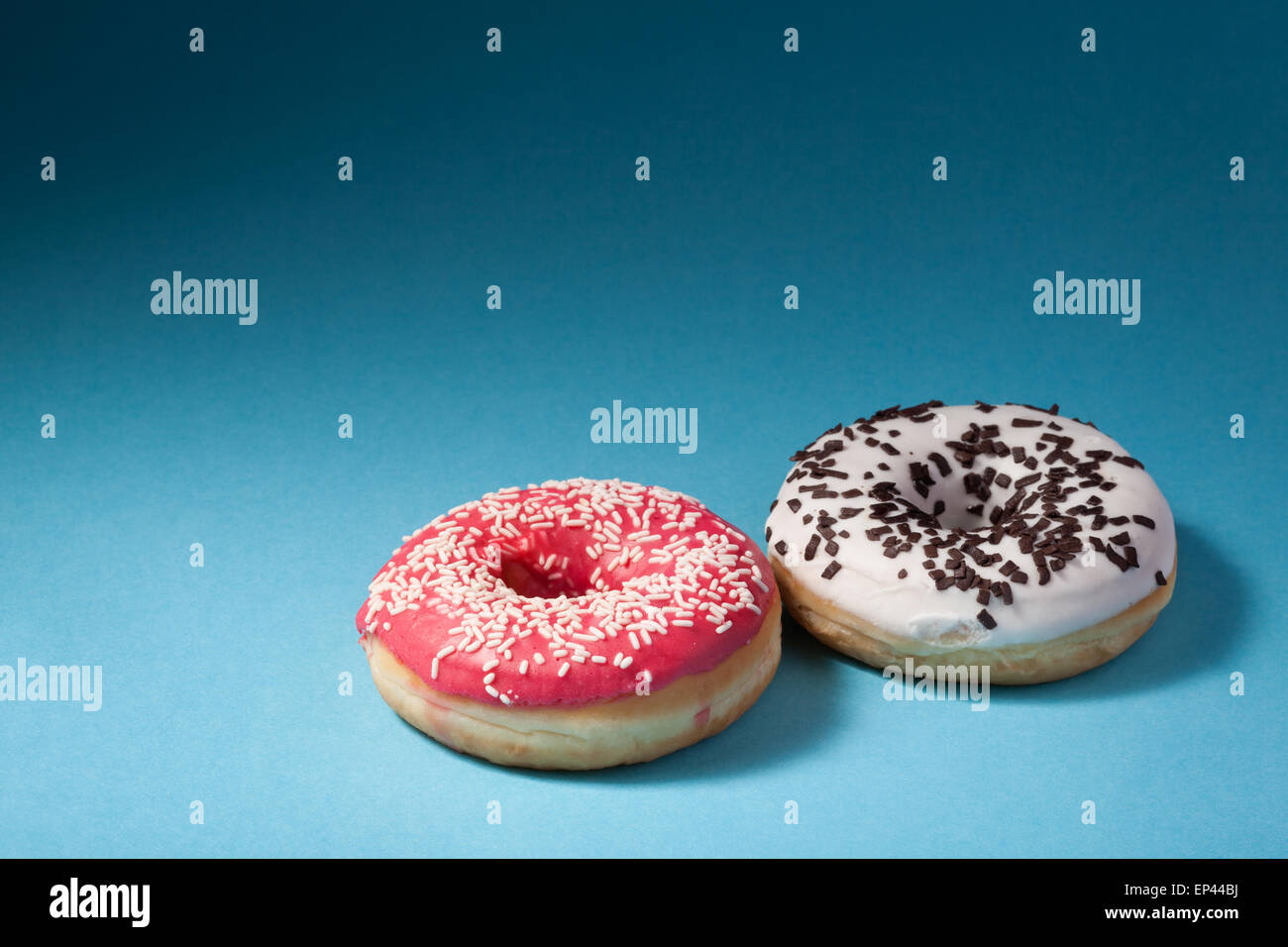 two donuts with red and white icing isolated Stock Photo - Alamy