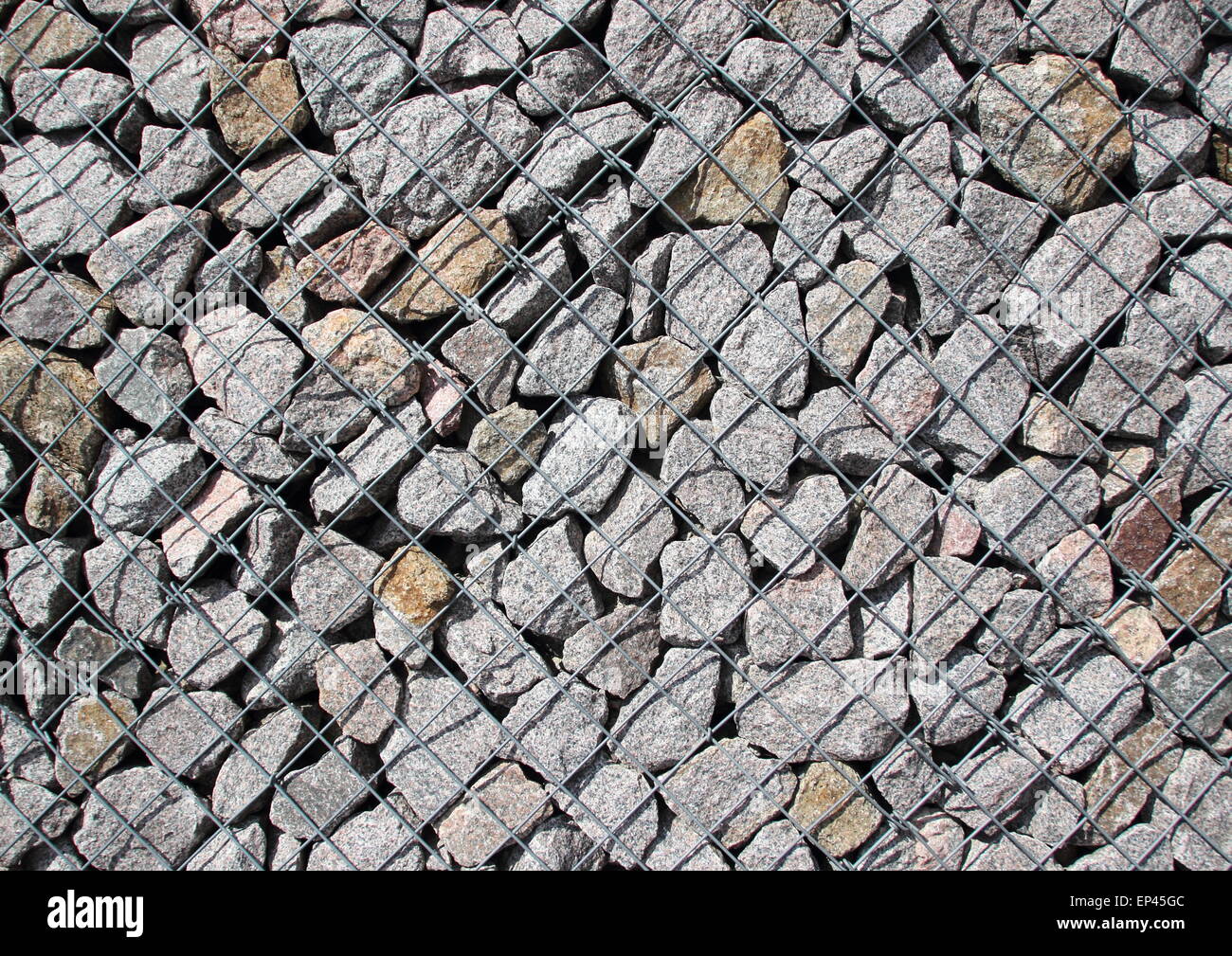 Rocks in solid metal grid construction diagonal Stock Photo - Alamy