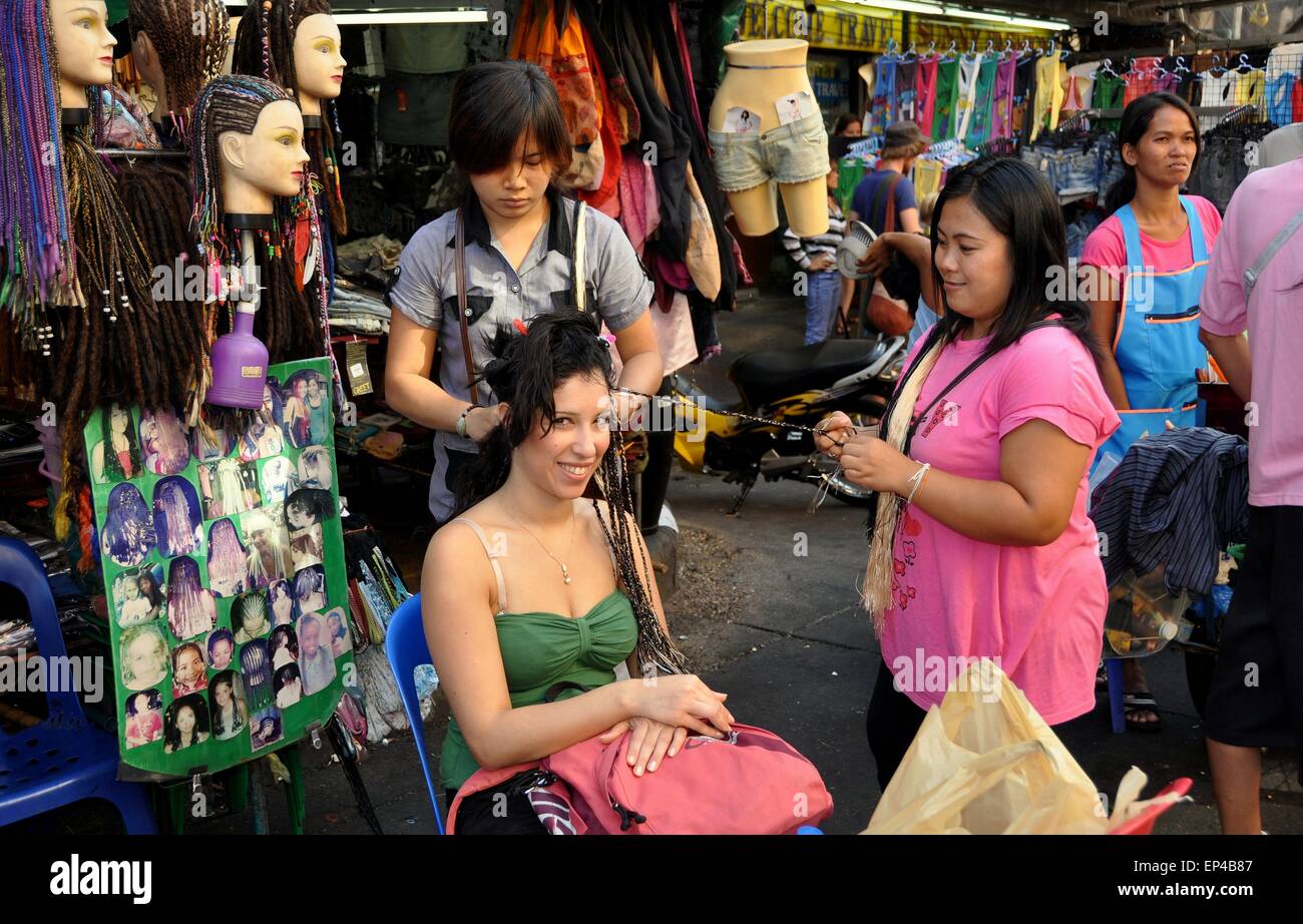Bangkok, Thailand: Western woman having her hair braided by two Thai ...