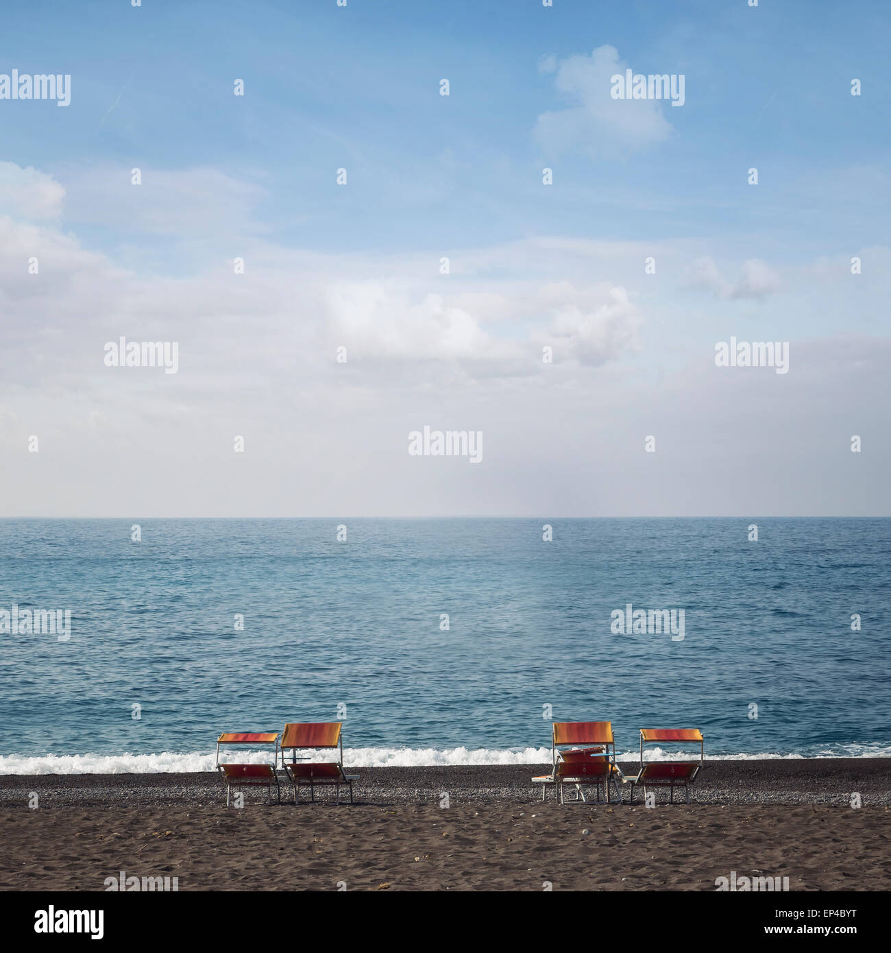 a beach in with four beach chairs Stock Photo - Alamy