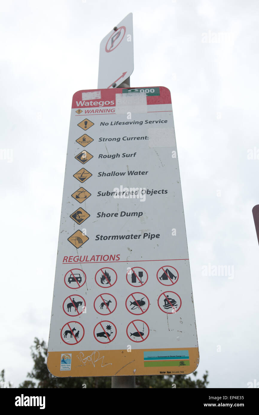 A wide low shot of a warning sign at Wategos Beach in Byron Bay ...