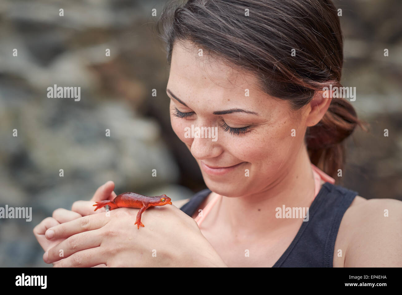 A young woman smiling while holding a Sierra Newt in Northern ...