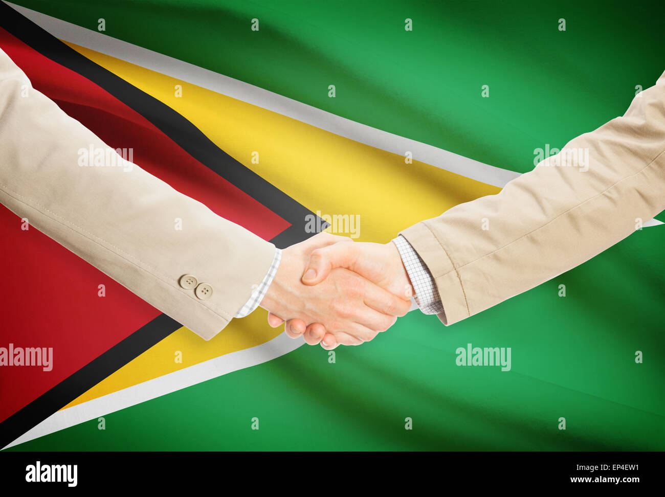 Businessmen shaking hands with flag on background - Guyana Stock Photo ...