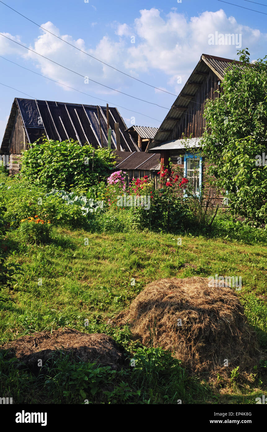 Village landscape - garden, hay and wooden houses Stock Photo - Alamy