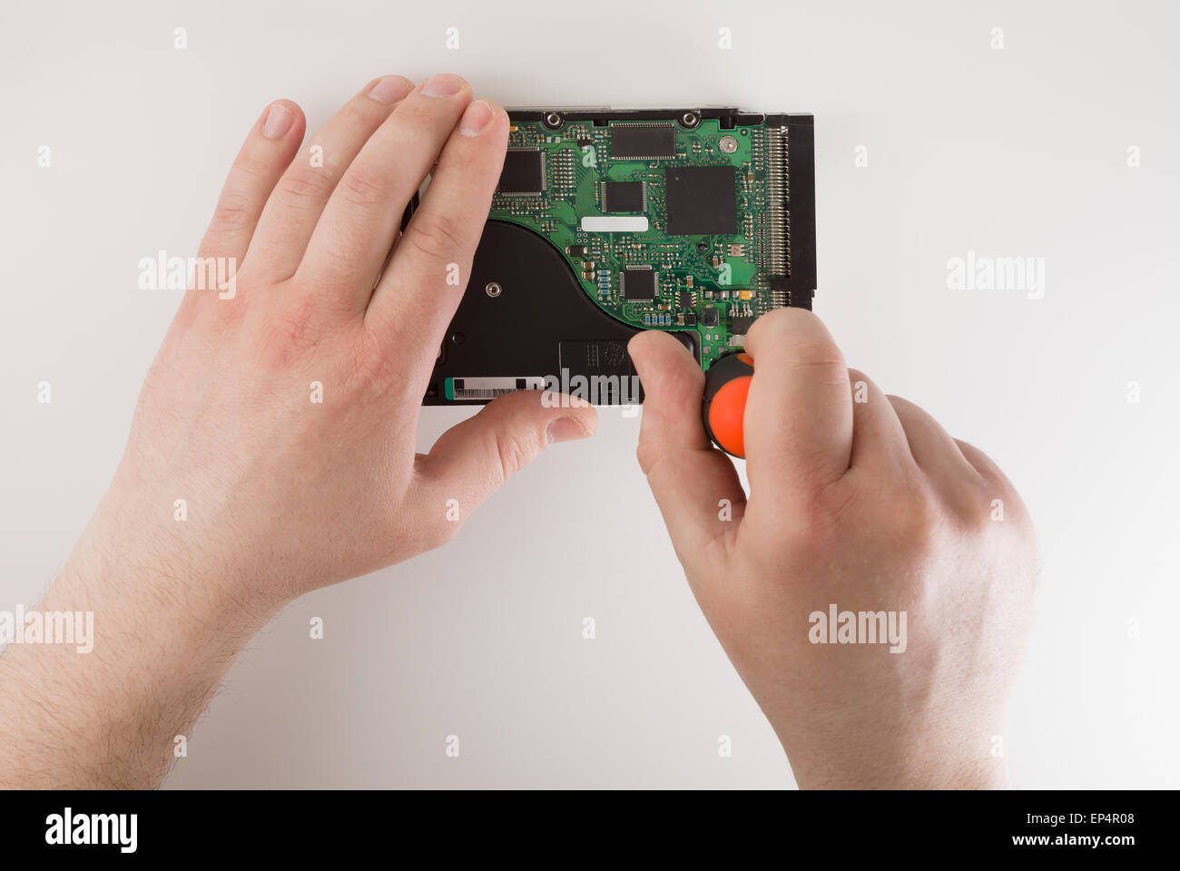 the computer hard drive in the course of dismantling on a white ...