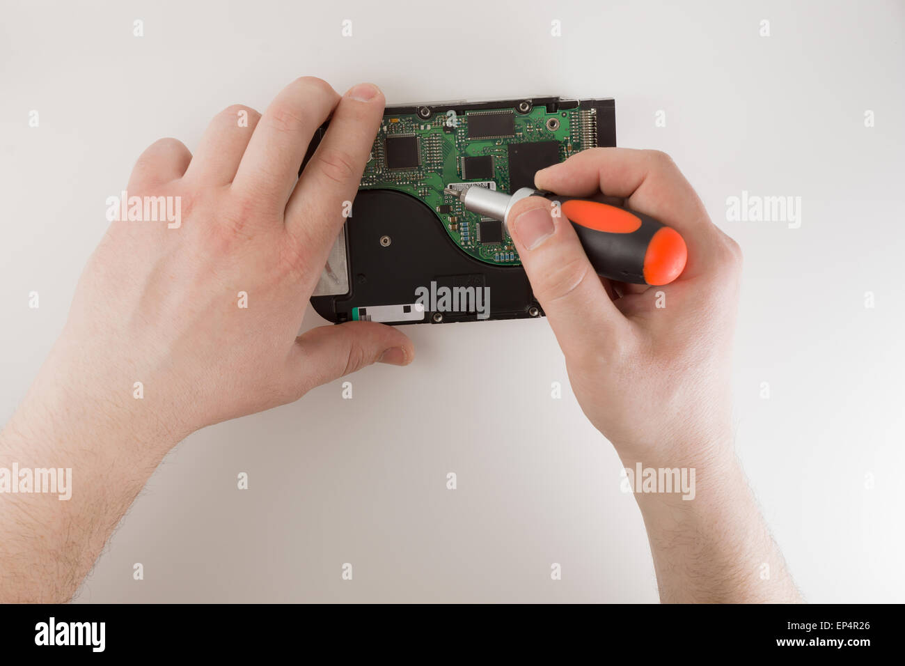 the computer hard drive in the course of dismantling on a white ...