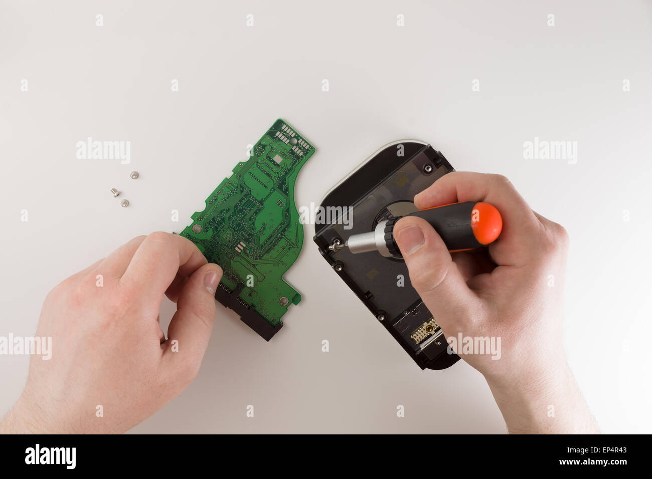the computer hard drive in the course of dismantling on a white ...
